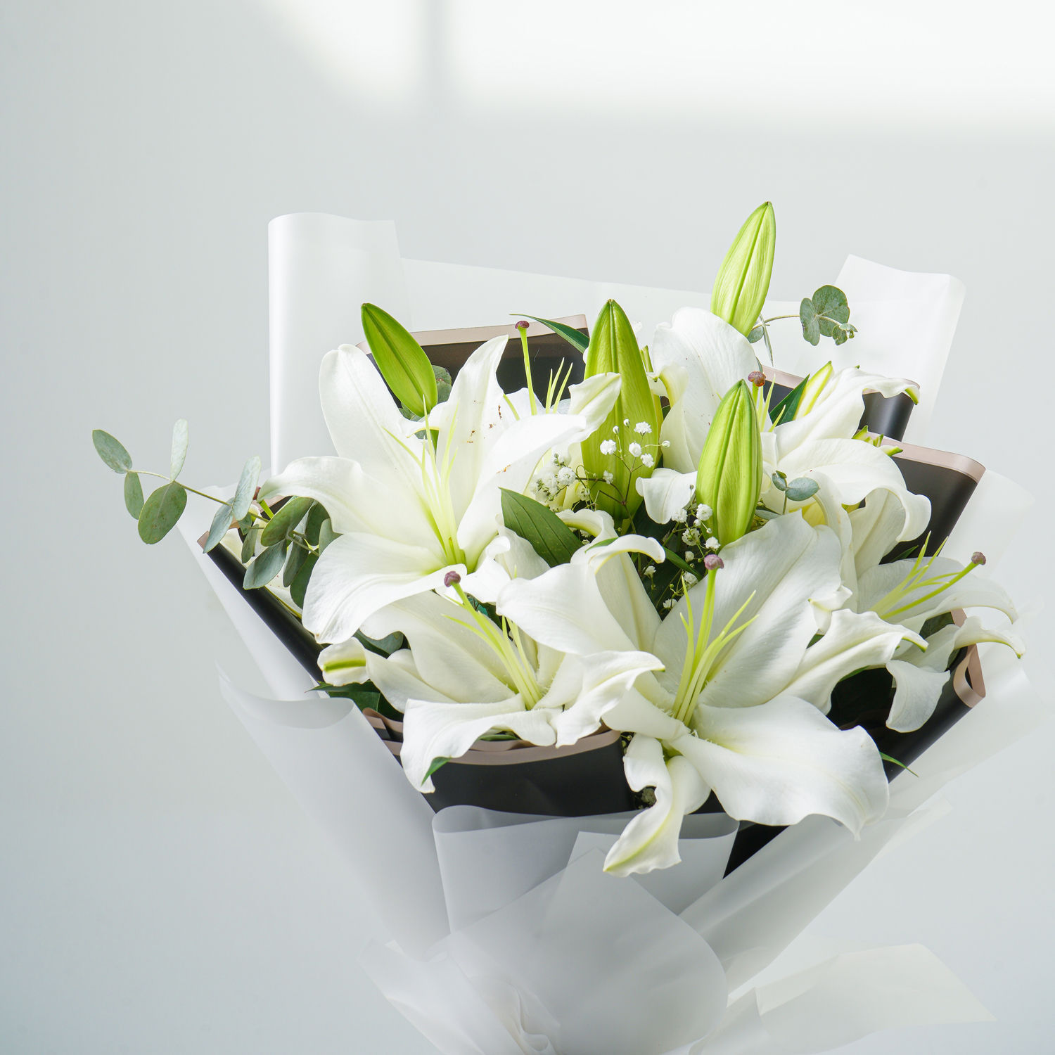 Charming White Lilies Hand Bouquet Delivery in Singapore - FNP SG